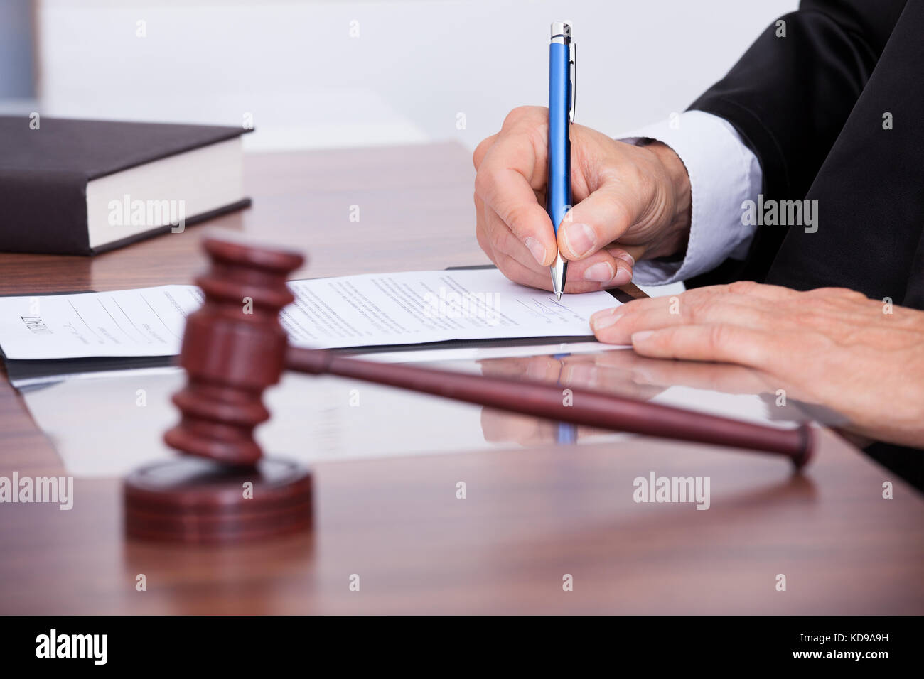 Male Judge Writing On Paper In Courtroom Stock Photo - Alamy
