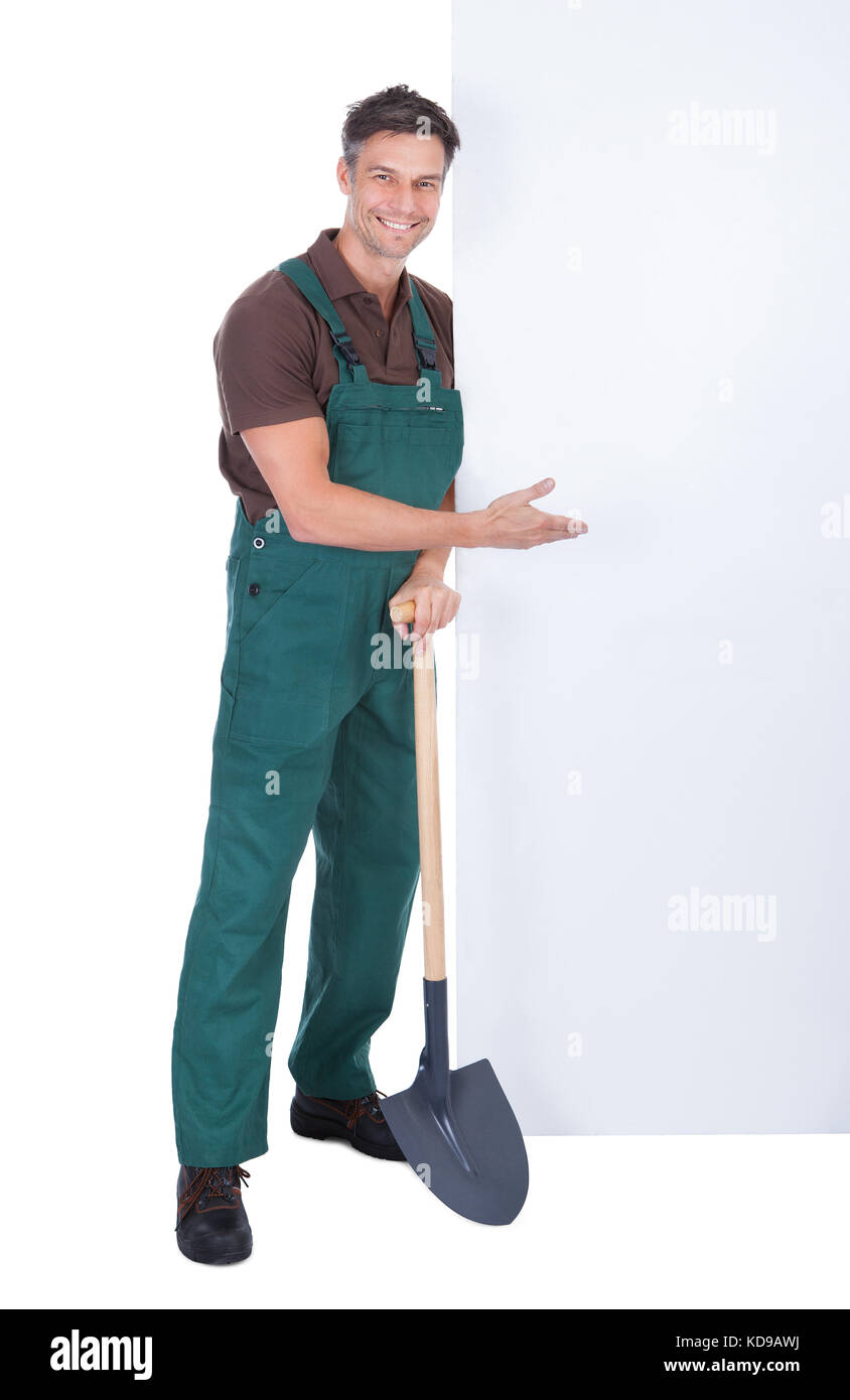 Portrait Of Cheerful Male Gardener With Shovel Presenting Blank Placard ...