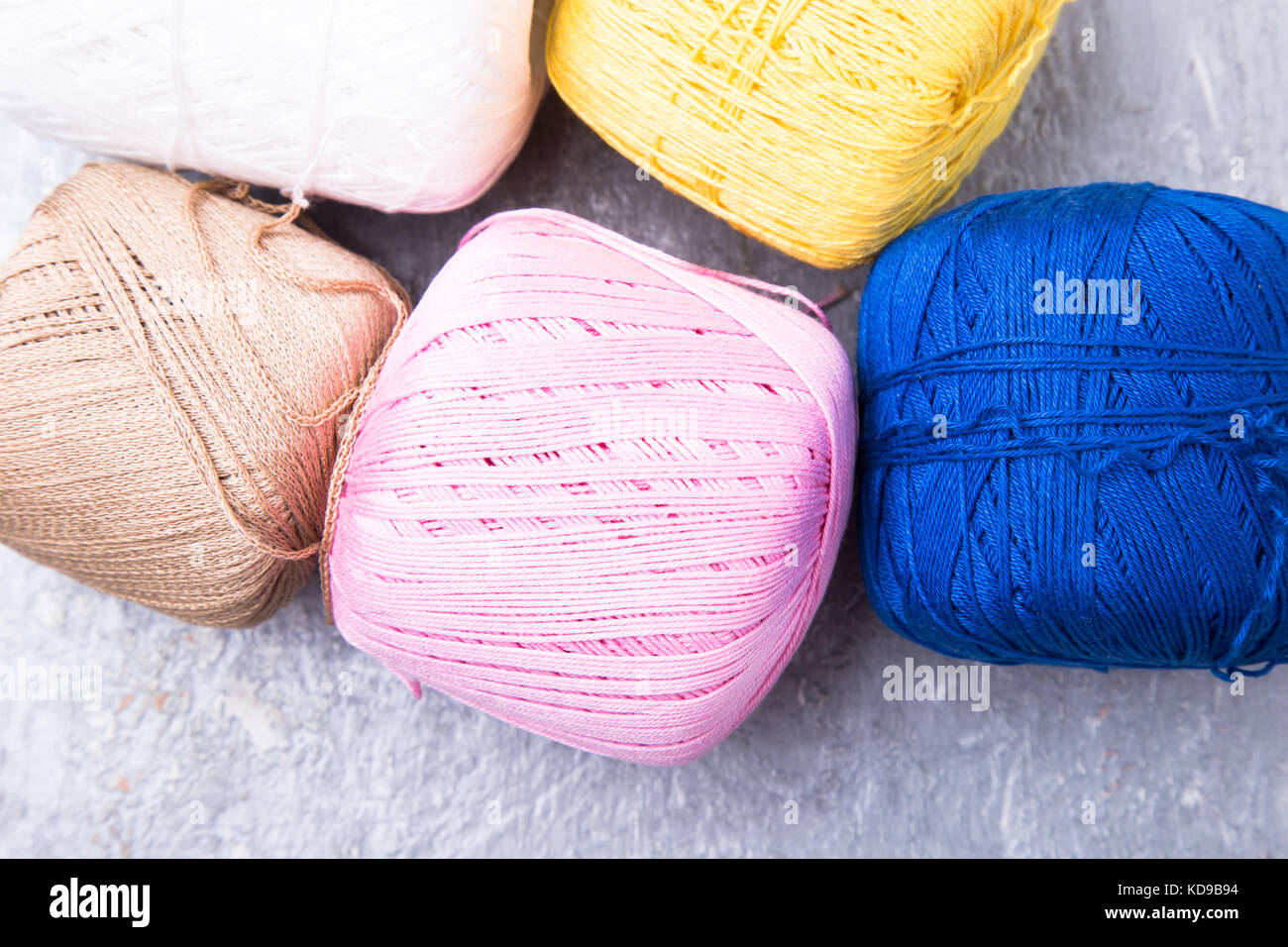 Multicolor knitting ball and needles on grey background. Top view. Copy ...