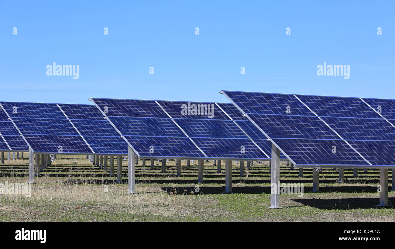 Solar panels in a field in the spring on a sunny day with blue skies ...