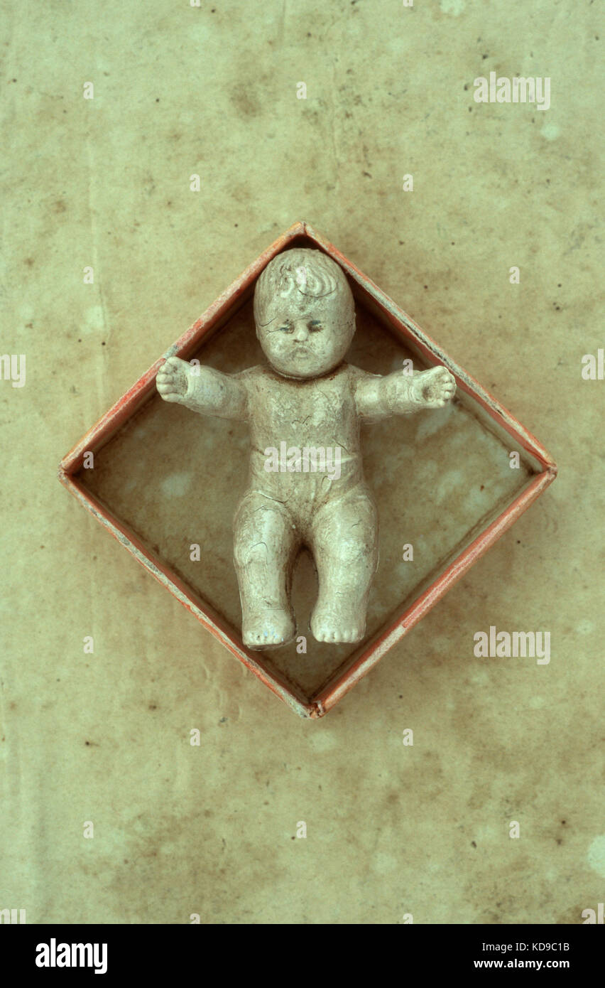 Vintage grubby model of baby or toddler with arms outsretched lying in ...