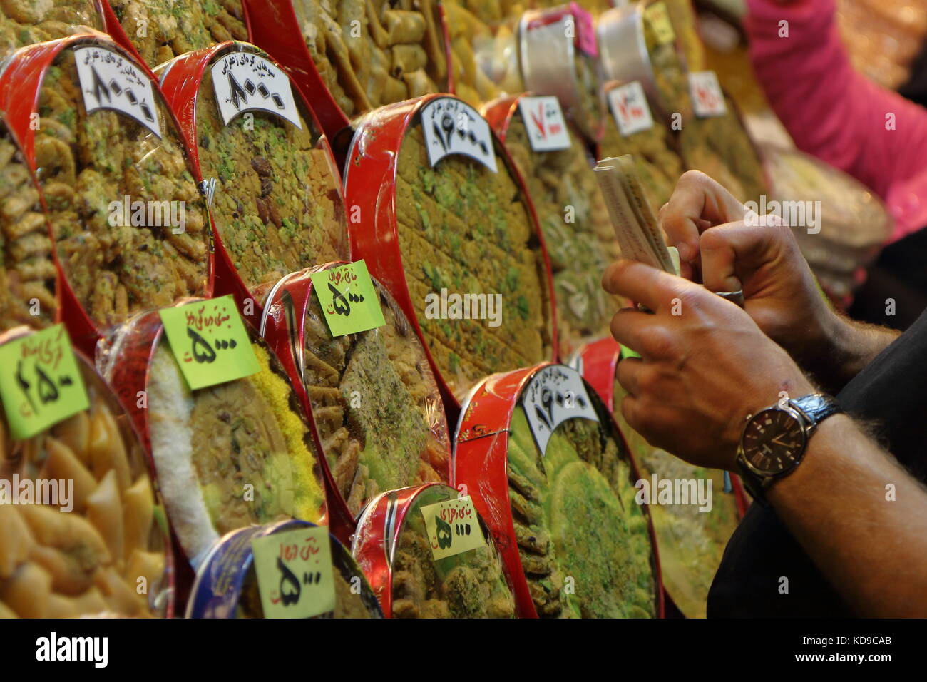Payment at an arabic sweets market: an adult is buying some sweets in a ...