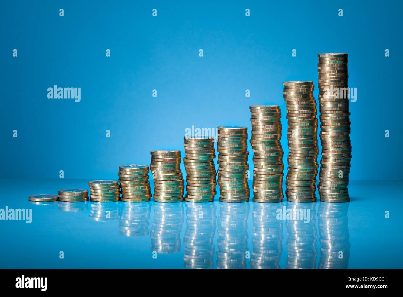 Stack Of One Euro Coins Over Blue Background Stock Photo - Alamy