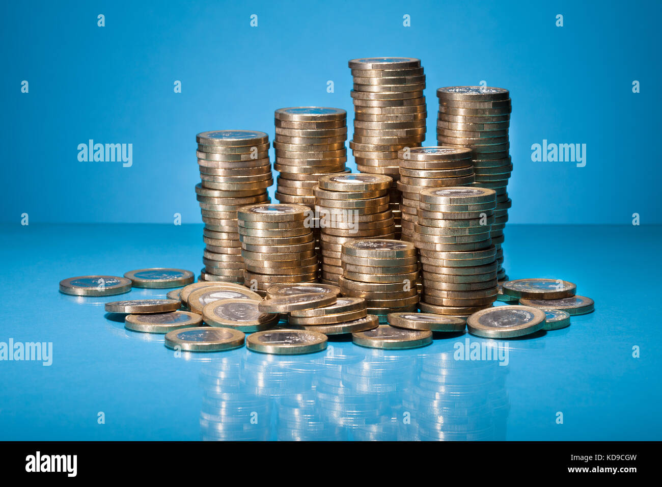 Stack Of Golden Coin Over Blue Background Stock Photo - Alamy
