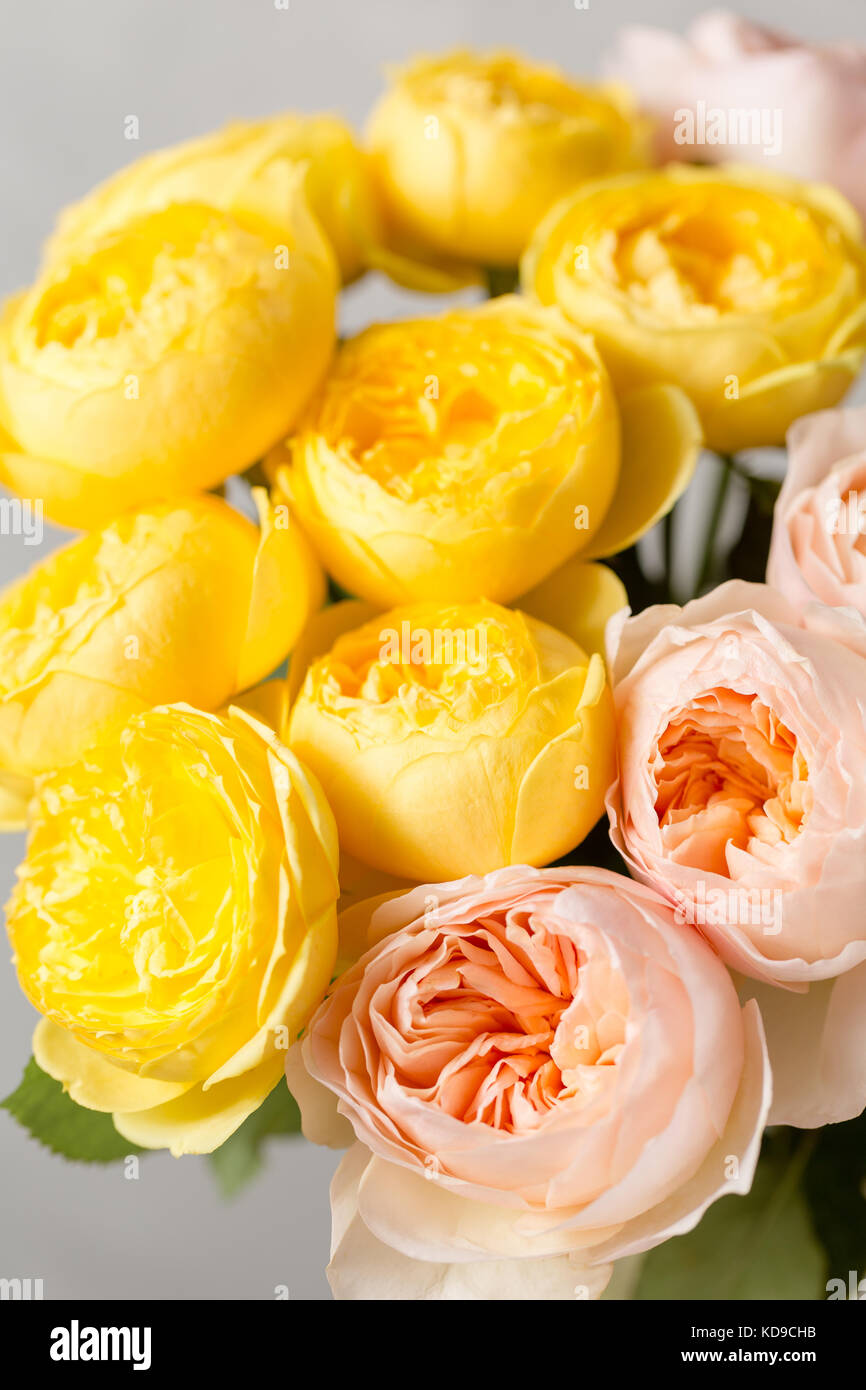 Bouquet of soft pink and yellow garden roses in a glass vase. Floral ...