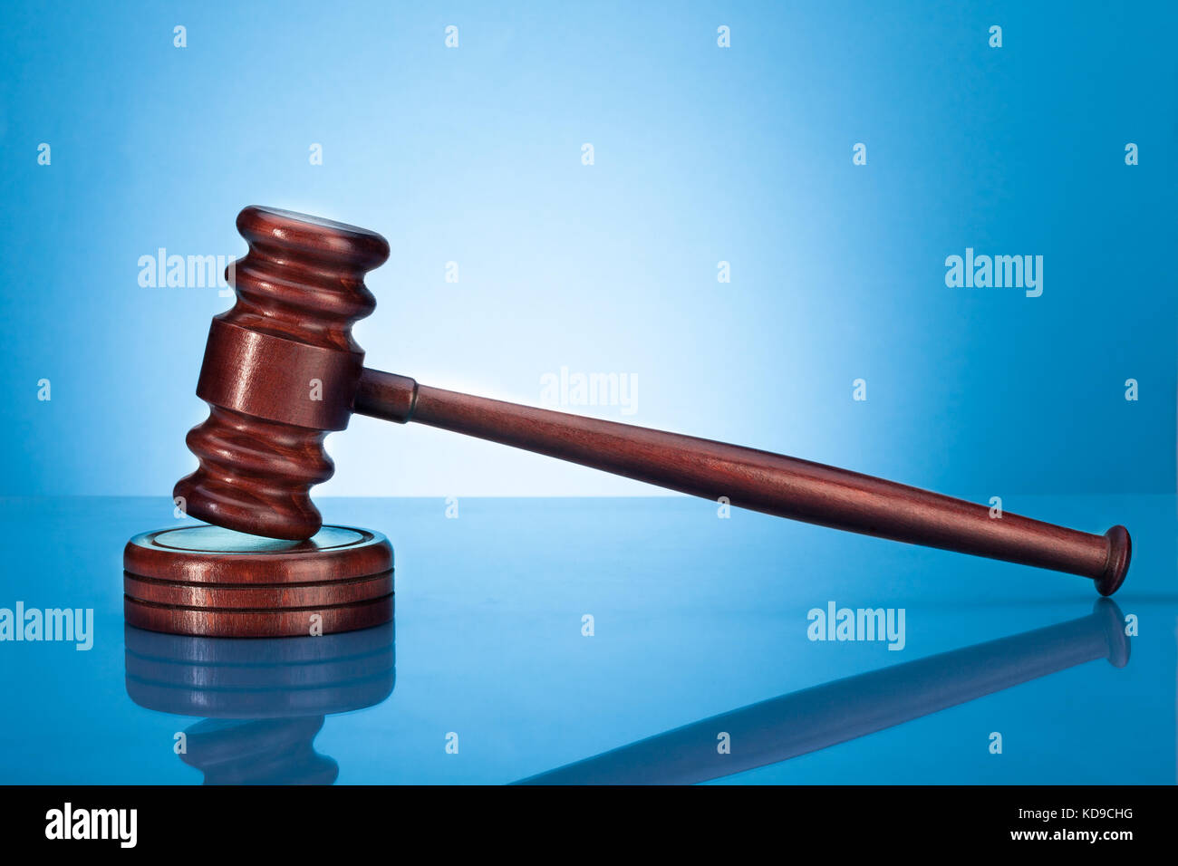 Wooden Gavel Resting On Block Over Blue Background Stock Photo - Alamy