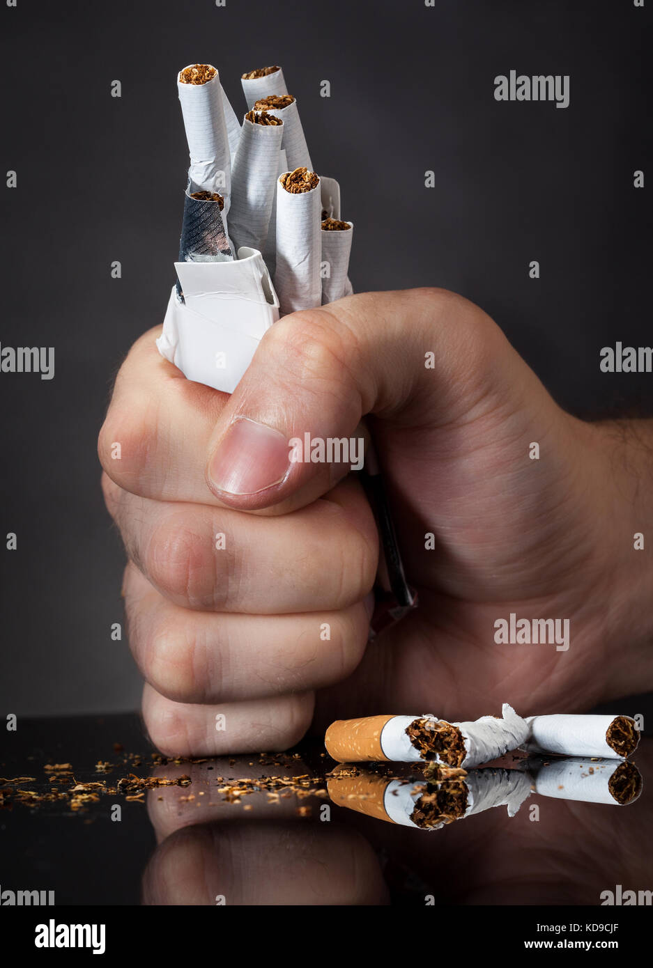 Close-up Of Man's Fist Crushing Cigarettes Over Black Background Stock ...