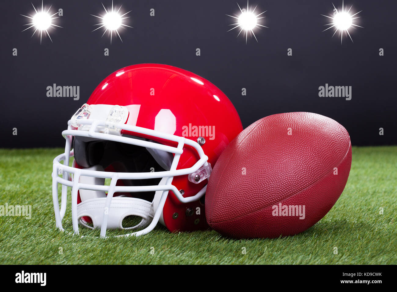 Red Sports Helmet Lying On Green Grass Field Stock Photo - Alamy