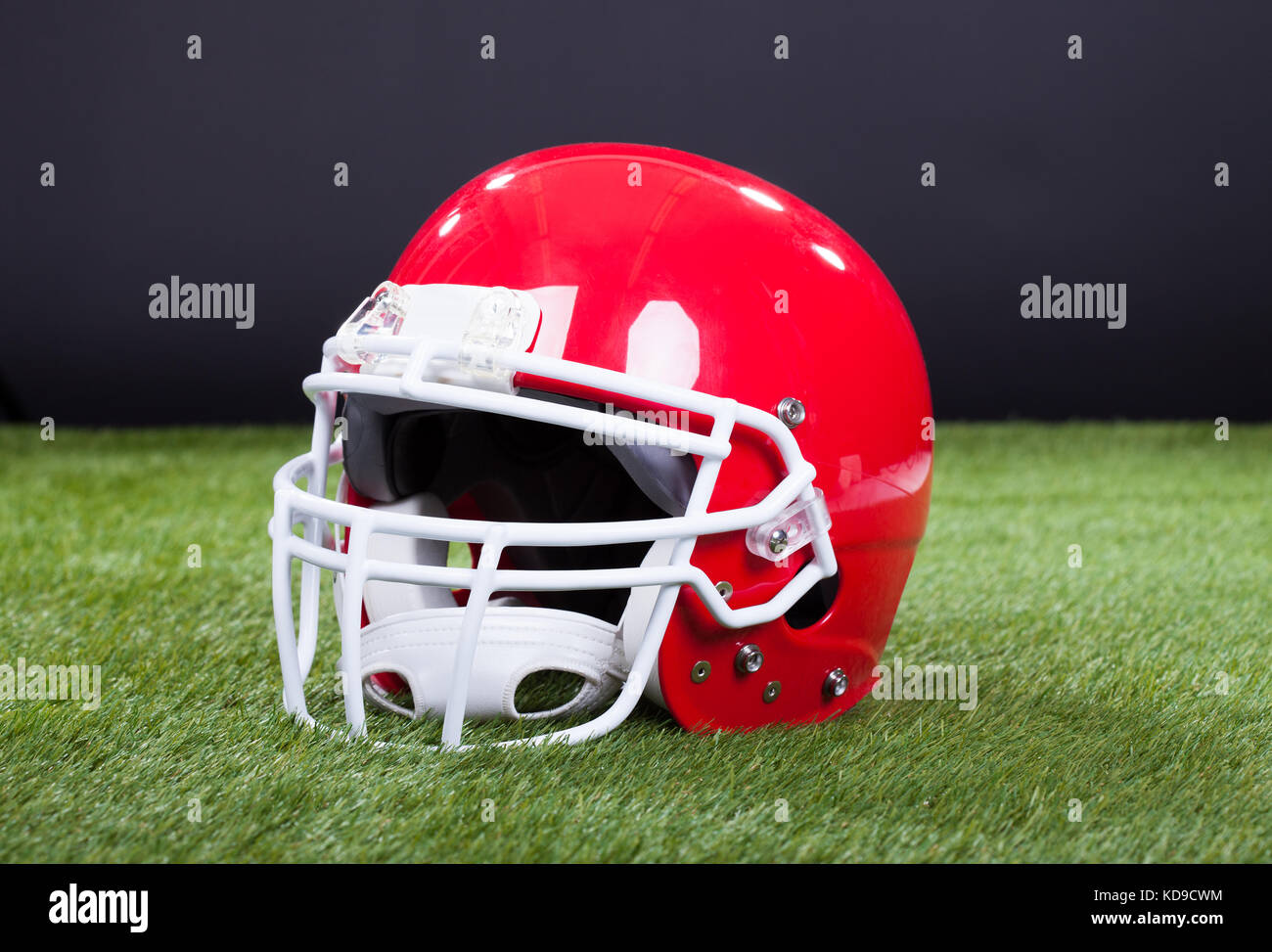 Red Sports Helmet Lying On Green Grass Field Stock Photo - Alamy