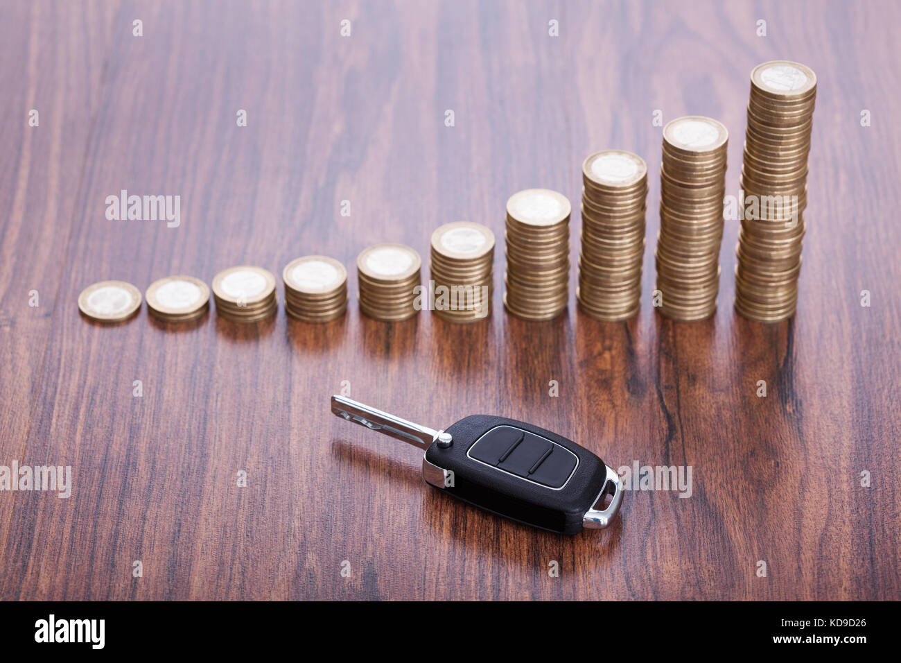 Stack Of Coins With Black Car Key Placed On Desk Stock Photo - Alamy