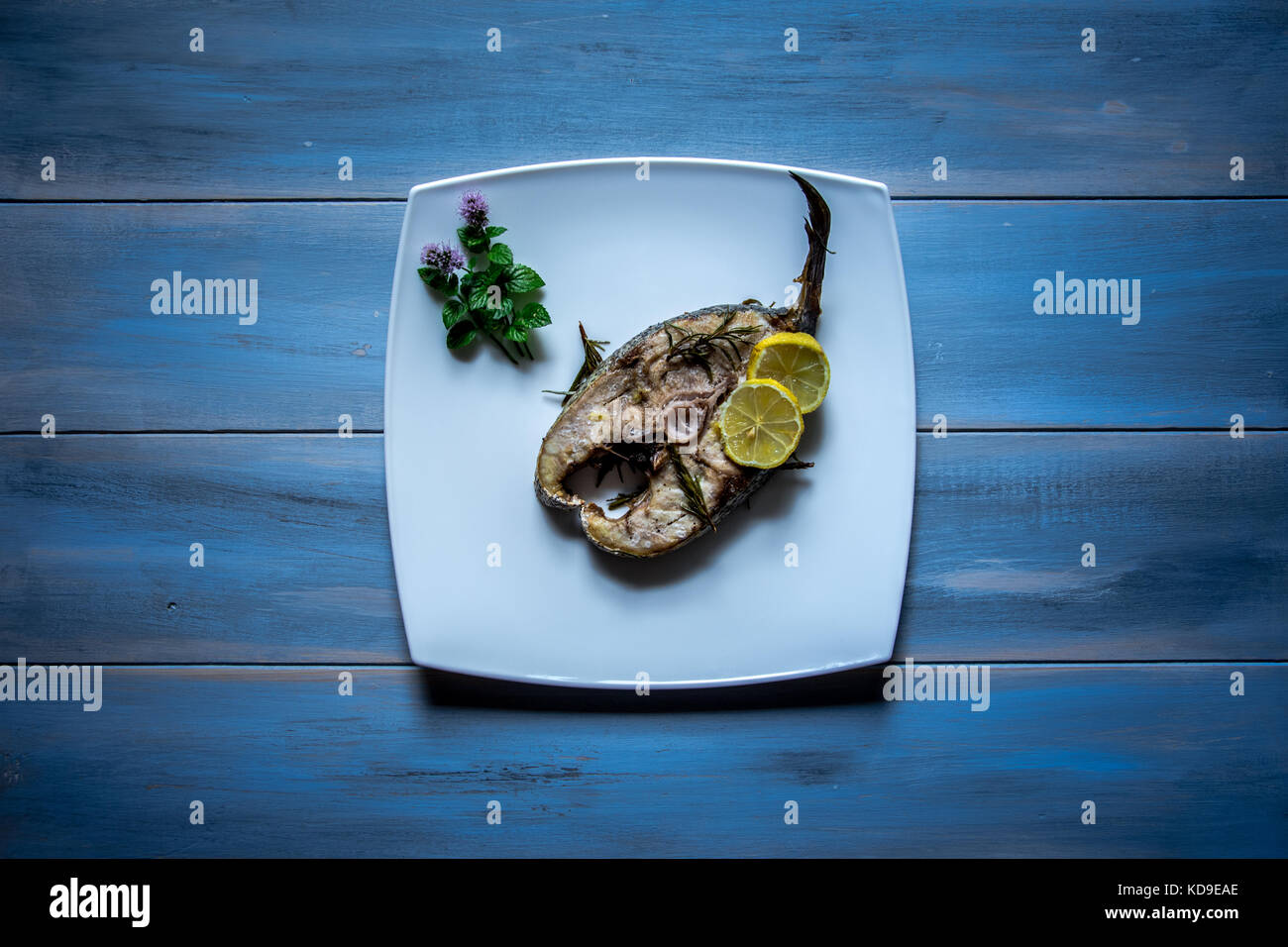 Grilled yellowtail amberjack with lemon slices on wooden background ...