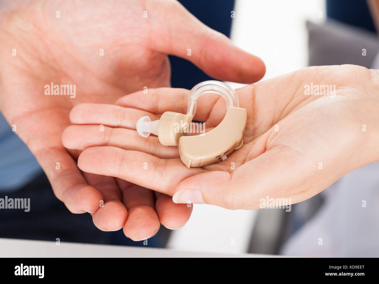Close-up Hand Giving Hearing Aid To A Person Stock Photo - Alamy