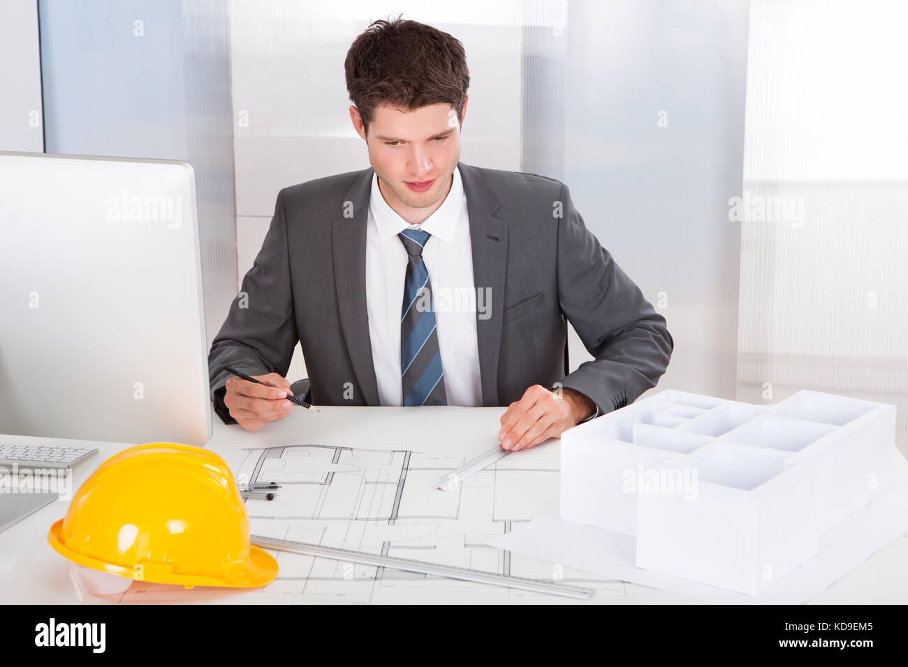 Portrait Of A Young Architect Drawing Plan On Blueprint Stock Photo - Alamy