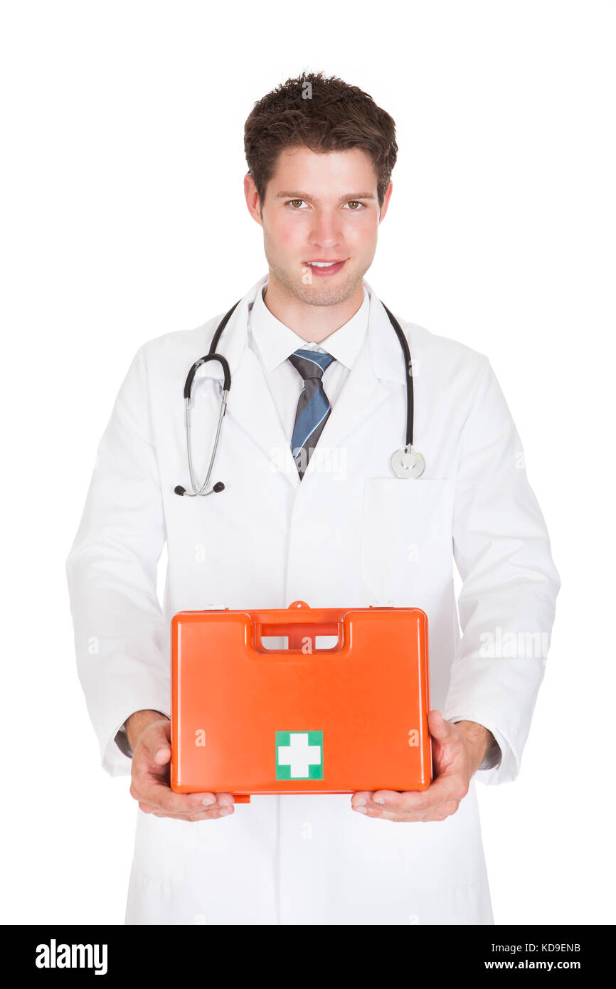 Portrait Of Male Doctor Holding First Aid Box Over White Background ...