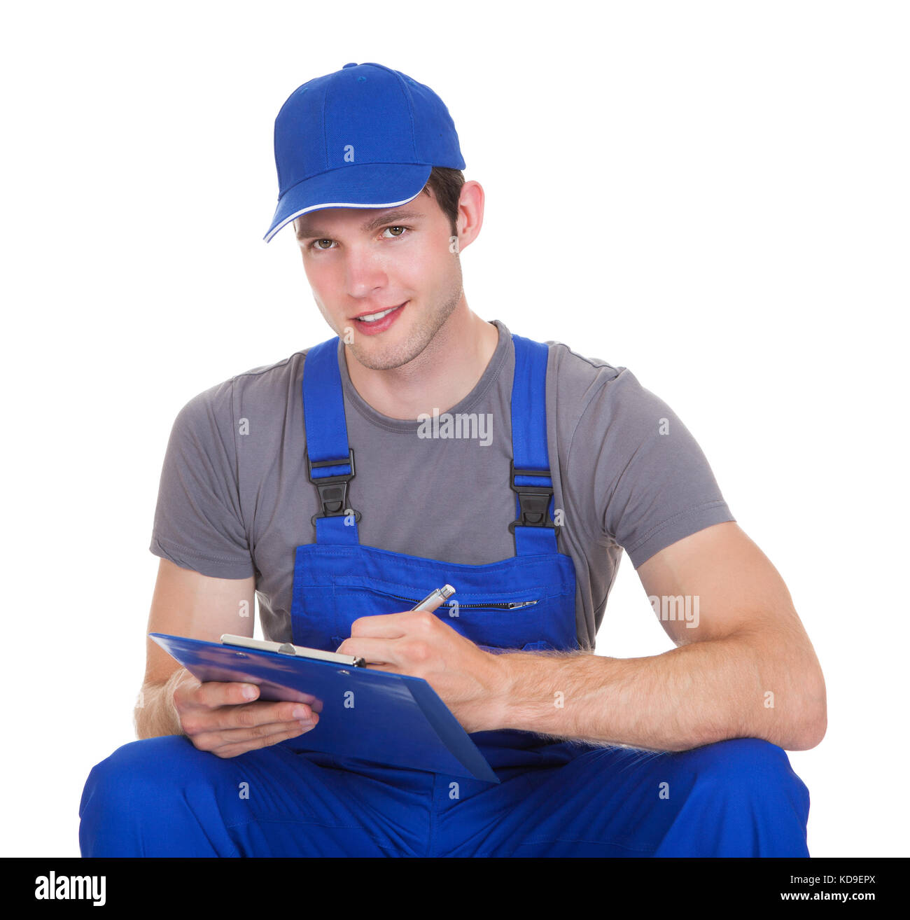 Young Construction Worker Writing On Clipboard Over White Background ...