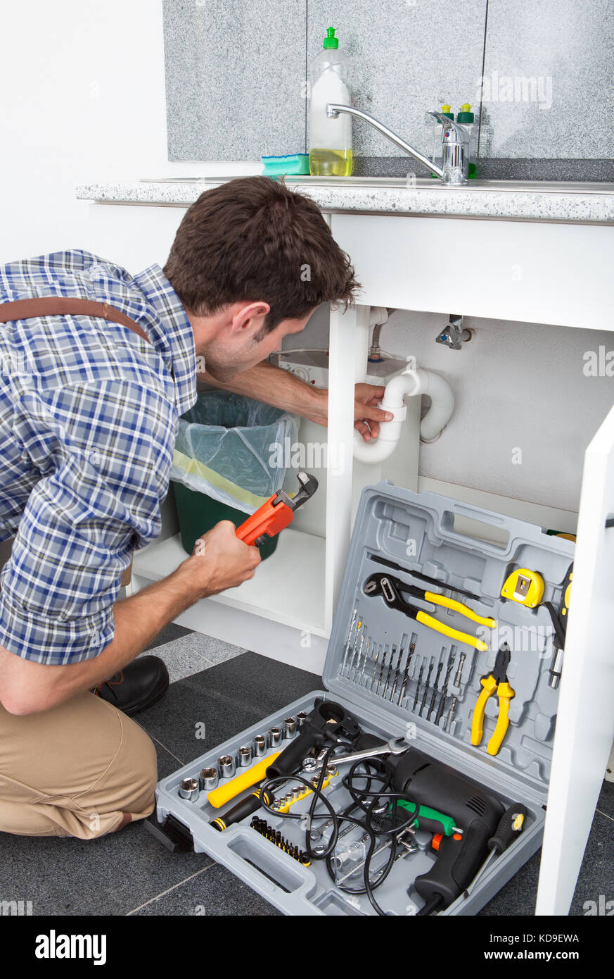 Young Plumber Working With Pipe Wrench In Kitchen Stock Photo - Alamy