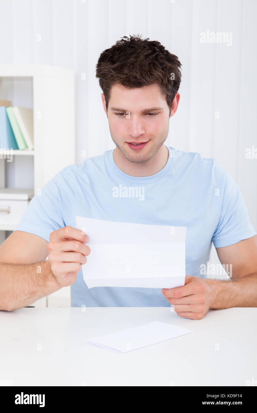 Happy Young Man Reading Paper Holding In Hands Stock Photo - Alamy