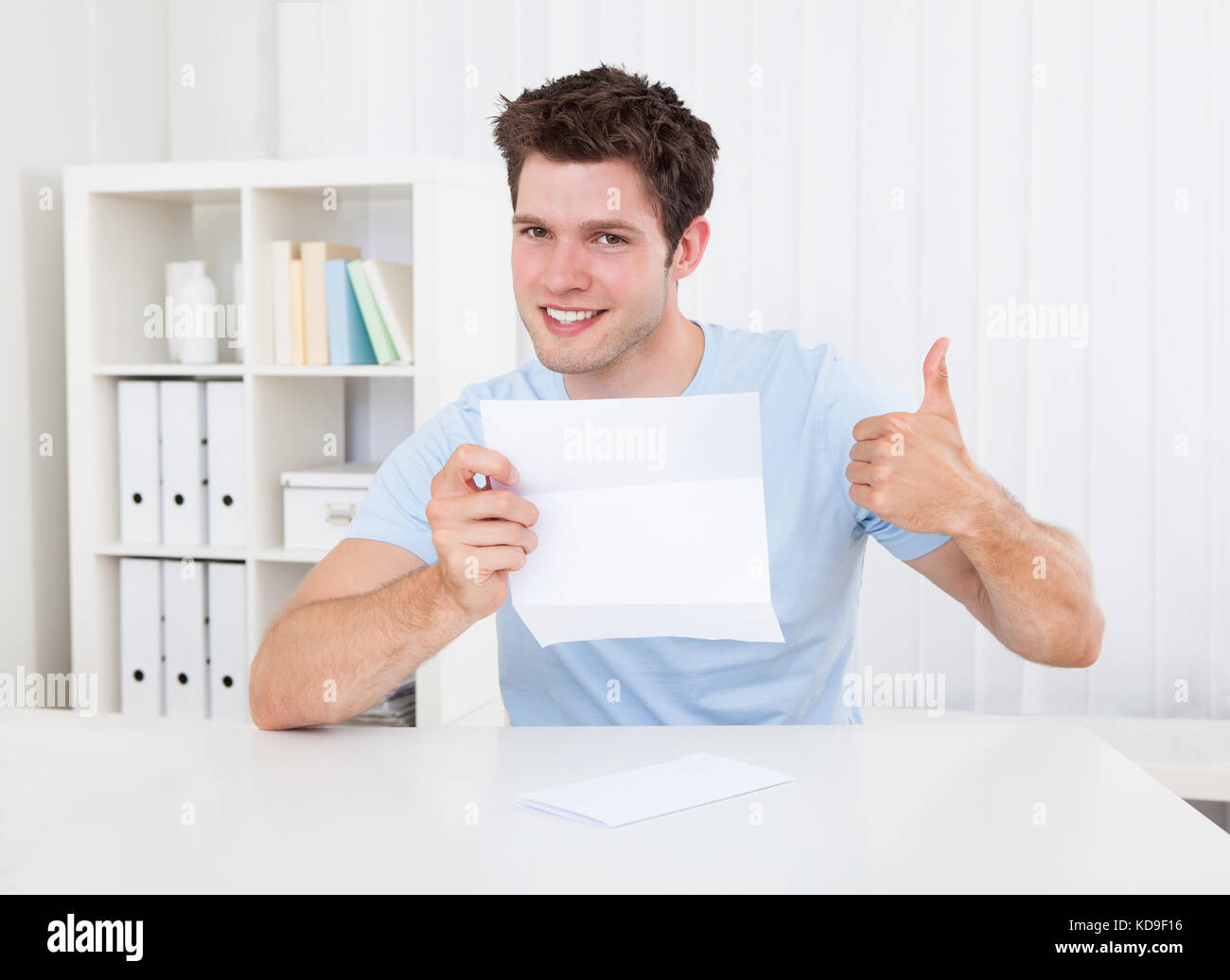 Happy Young Man Reading Paper Holding In Hands Stock Photo - Alamy