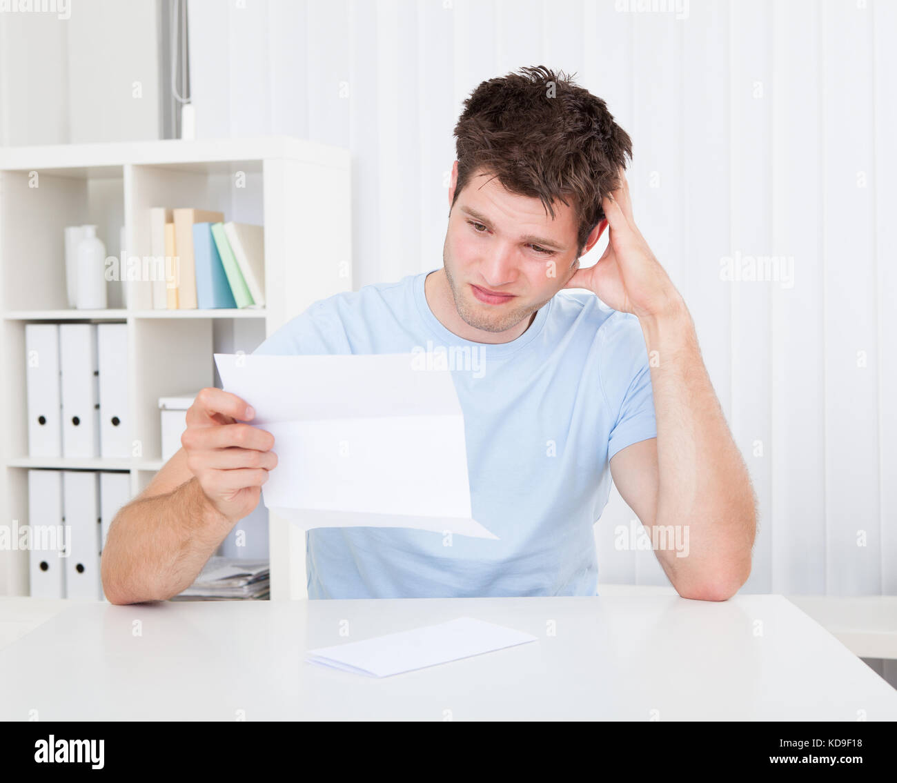 Contemplated Young Man Reading Paper Holding In Hands Stock Photo - Alamy