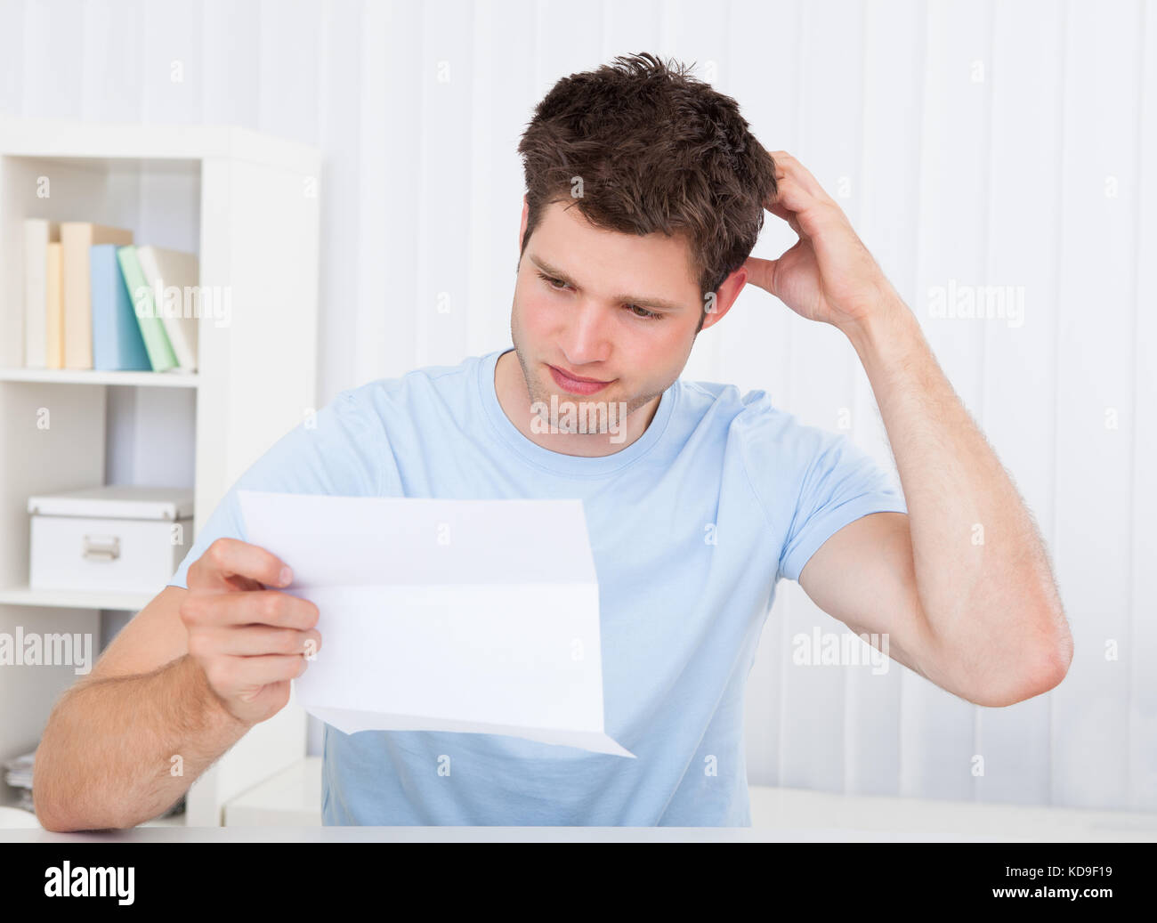 Contemplated Young Man Reading Paper Holding In Hands Stock Photo - Alamy