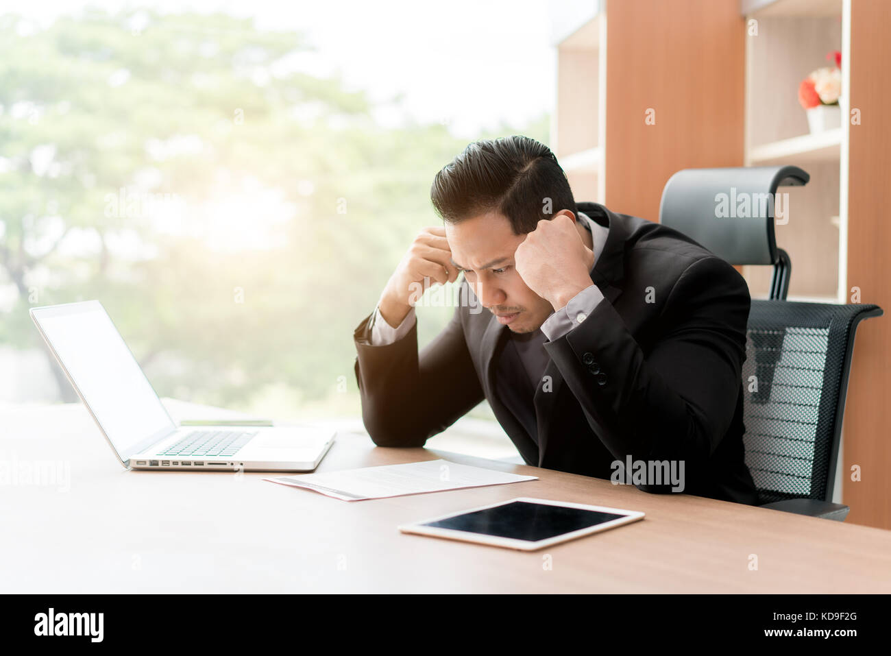 Portrait of tired young Asian business man feeling stress from work ...