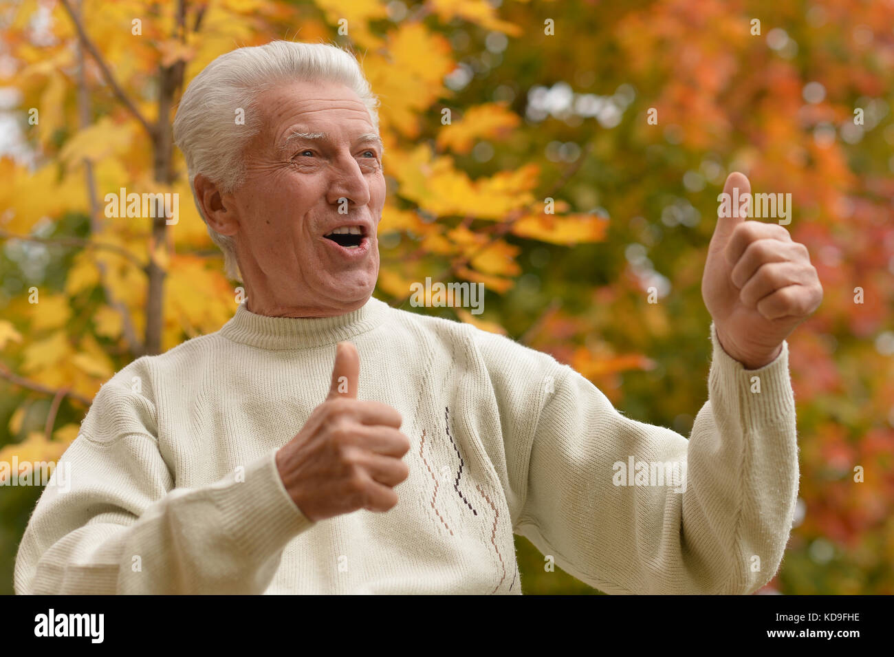 Senior man showing thumbs up Stock Photo - Alamy