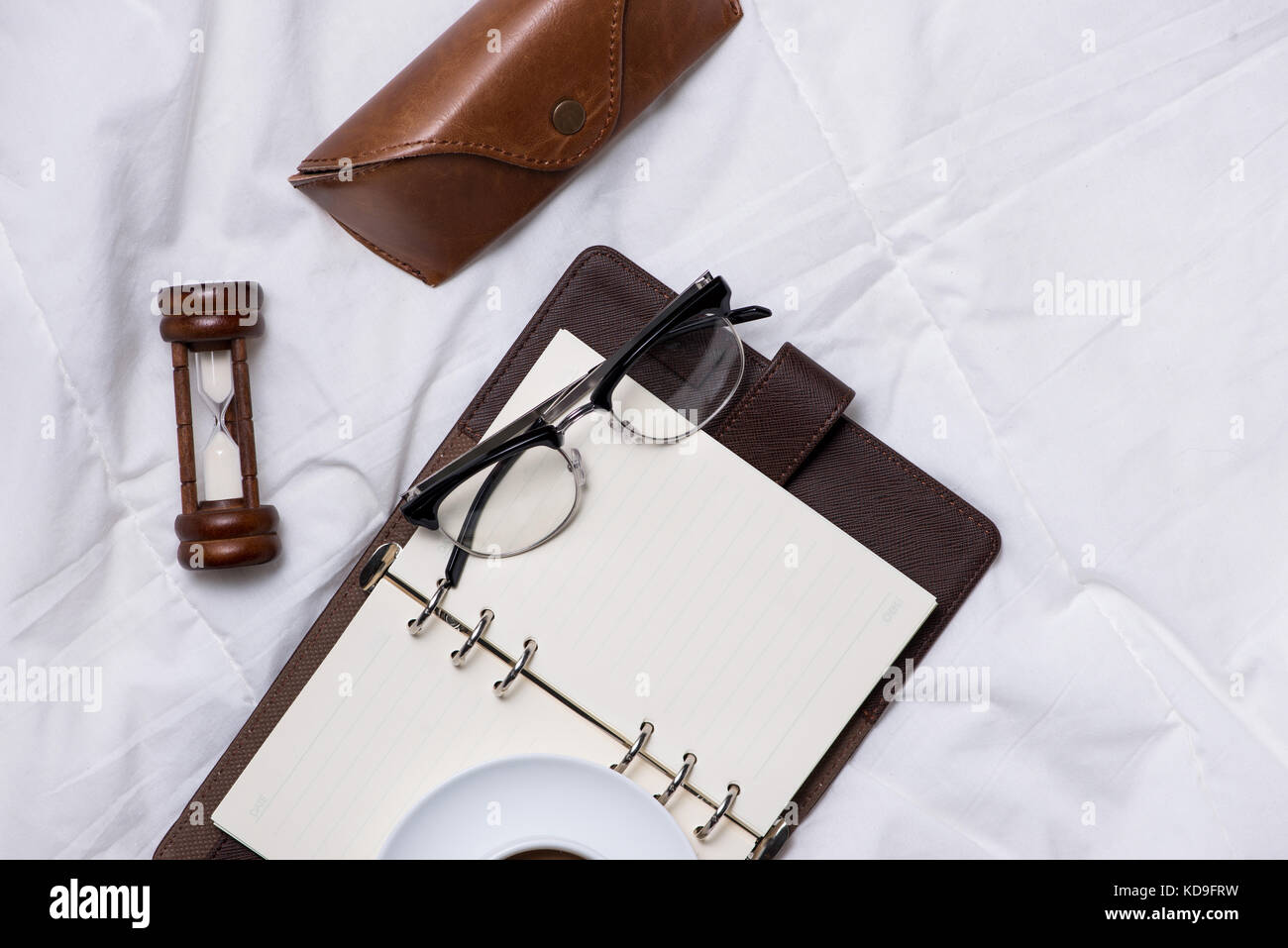 Morning Coffee and Diary with Clock and wooden pencil on cloth top view ...