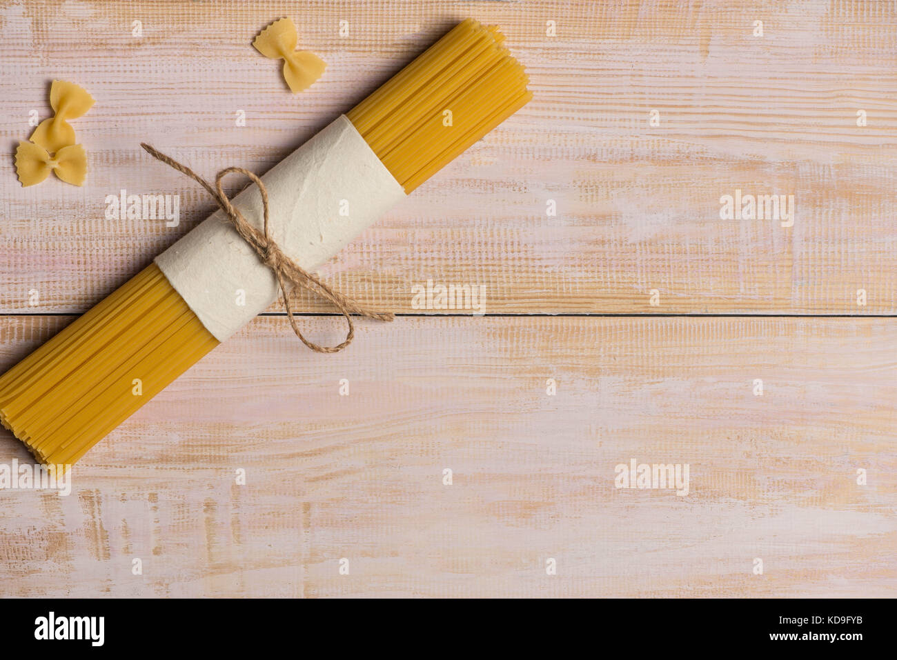 Dry spaghetti pasta tied up with rope on dark wooden table Stock Photo ...