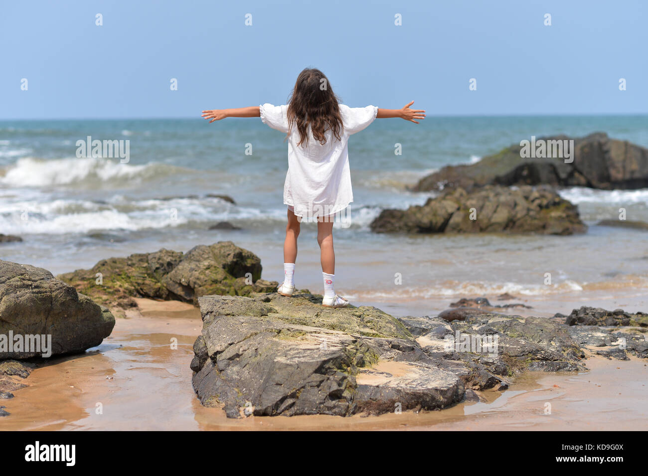 Little girl standing on rock Stock Photo - Alamy
