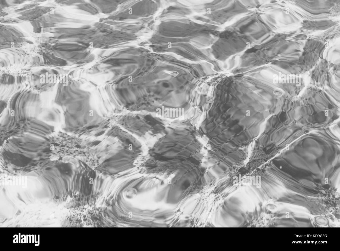 Refraction of light in clear water with small waves. Black and white ...