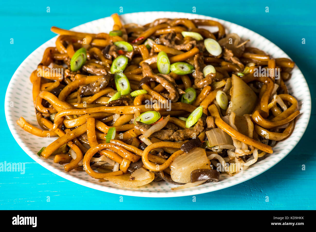 Oriental Shanghai Fried Beef Udon Noodles With Pak Choi Against a Blue ...