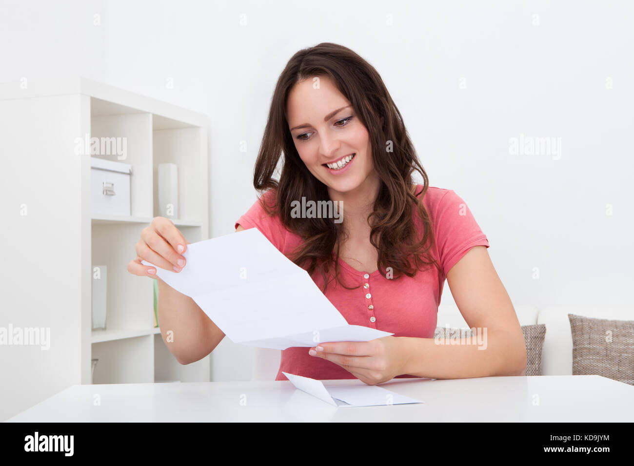 Portrait Of A Smiling Young Woman Reading Documents Stock Photo - Alamy