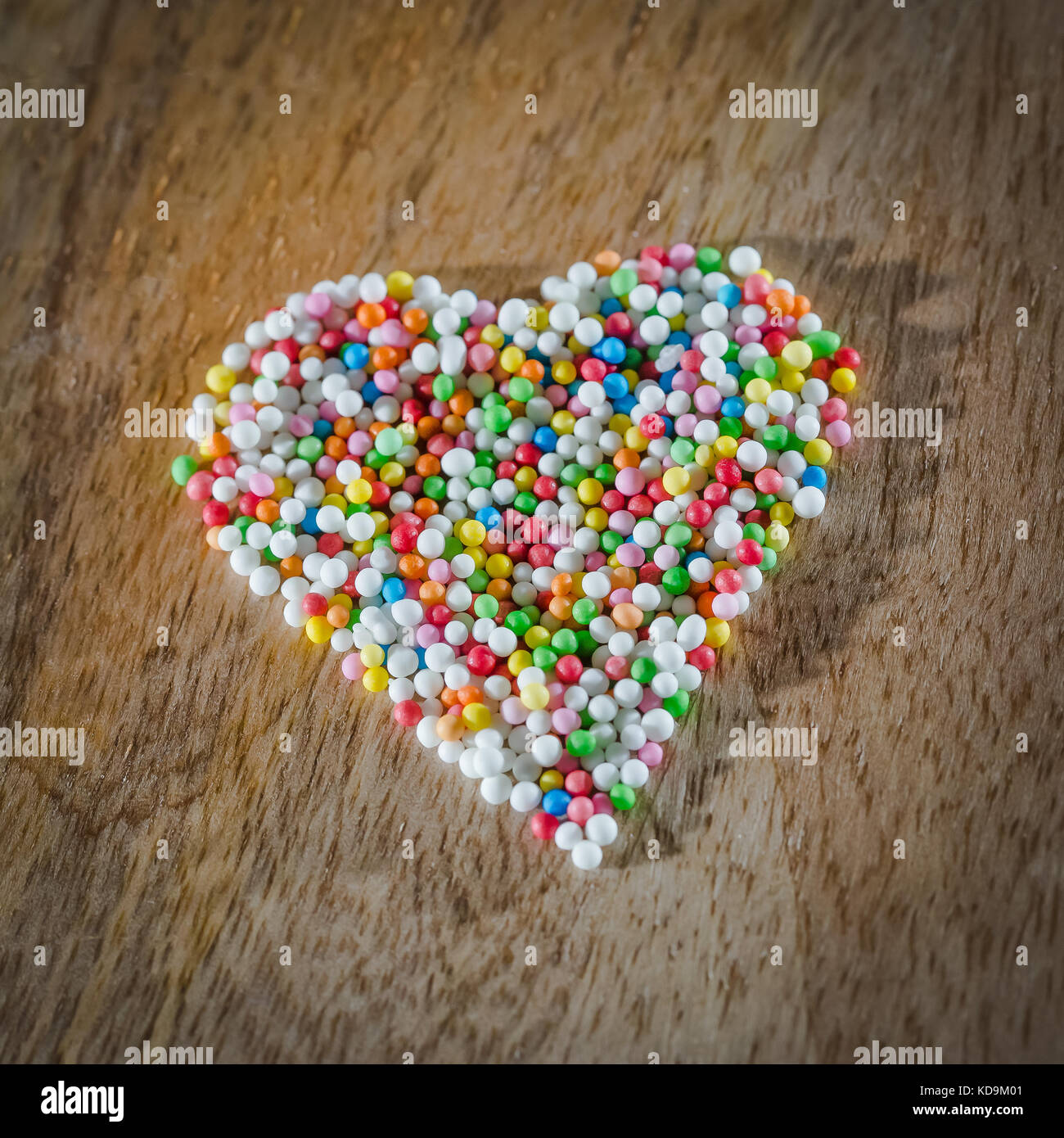 Heart shaped sprinkles on wood macro Stock Photo - Alamy