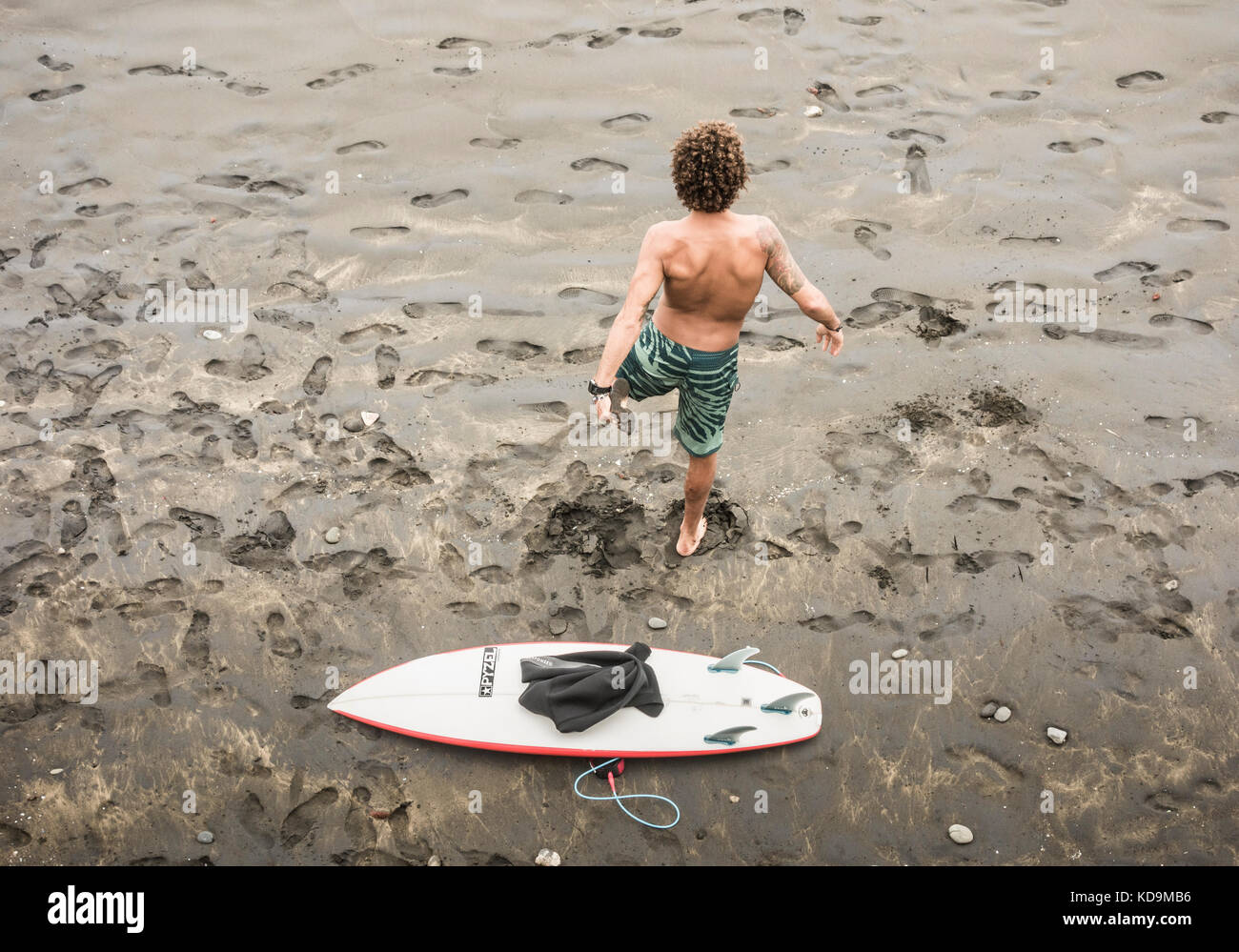 Surfer stretching on beach Stock Photo - Alamy