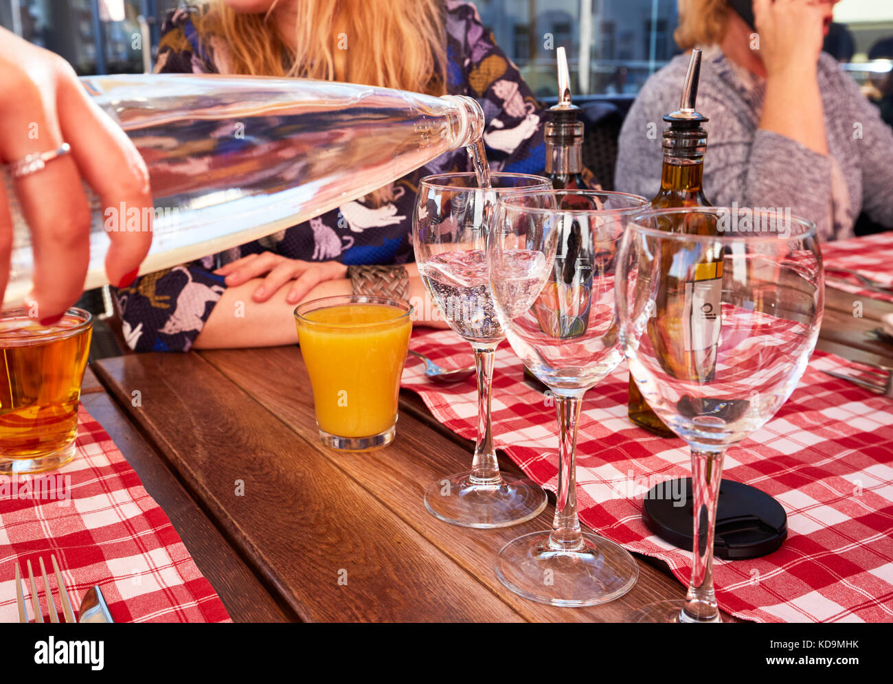 Waiter pouring mineral water from the glass bottle into a glass Stock Photo - Alamy