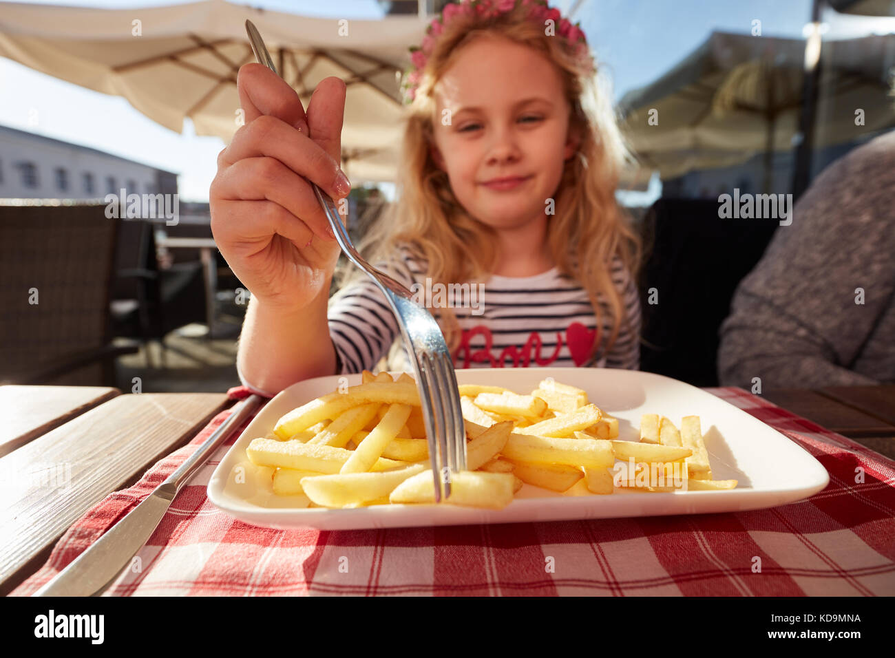 Close up photo preschool girl eats french fries potatoes sitting in ...