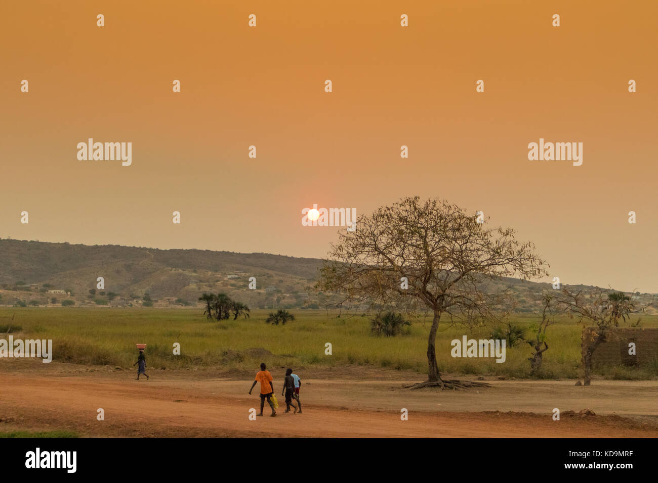 African rural people returning from work, with sunset. Sumbe. Angola ...