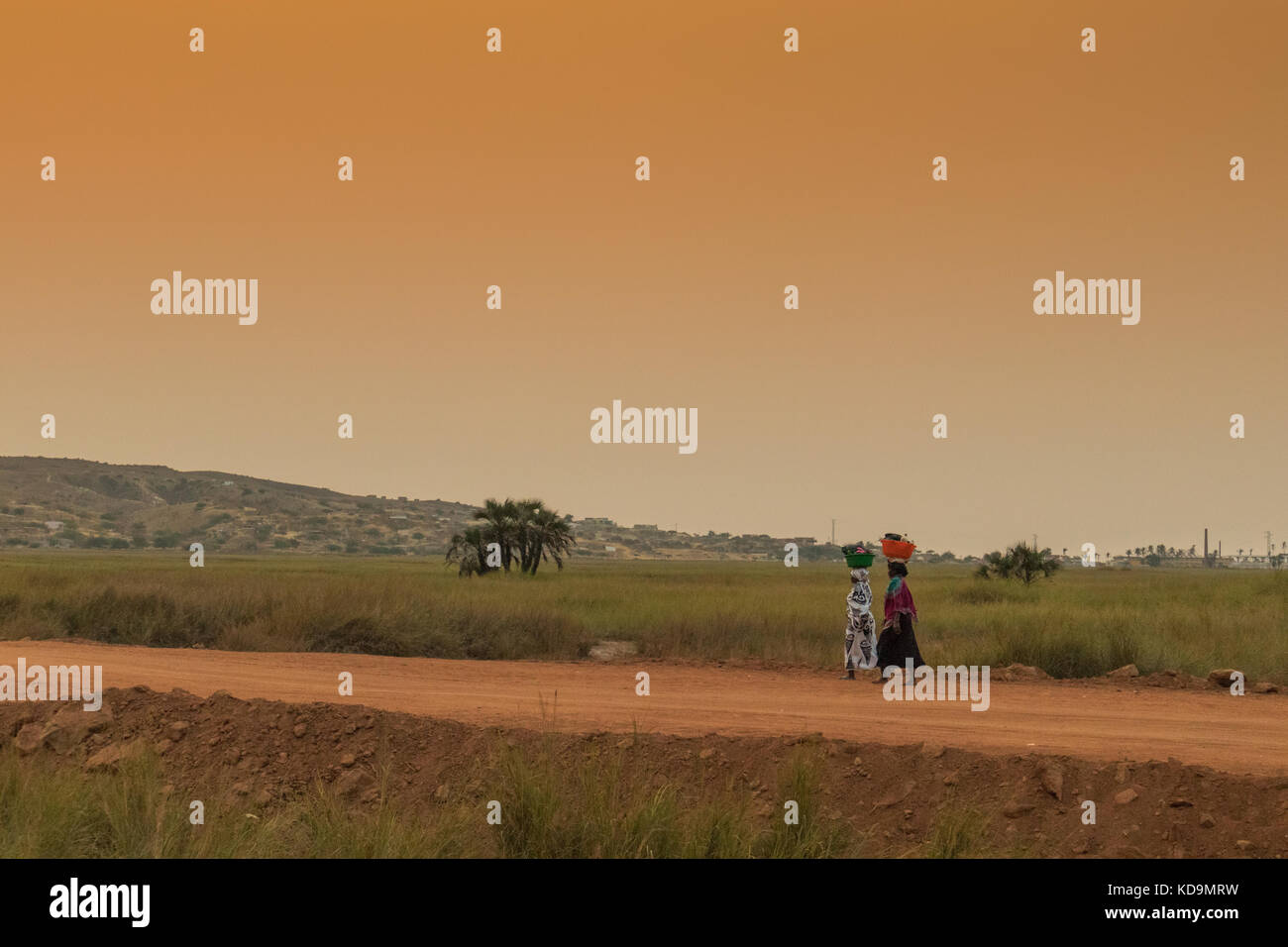 African rural people returning from work, with sunset. Sumbe. Angola ...