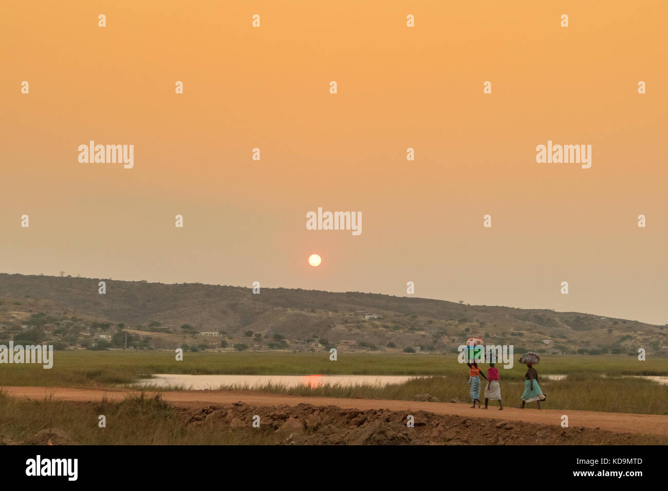 African rural people returning from work, with sunset. Sumbe. Angola ...