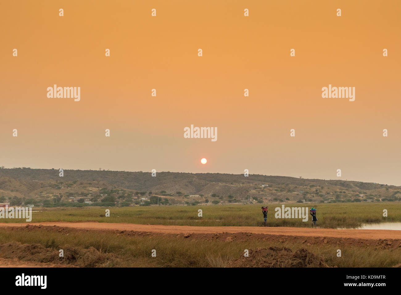African rural people returning from work, with sunset. Sumbe. Angola ...