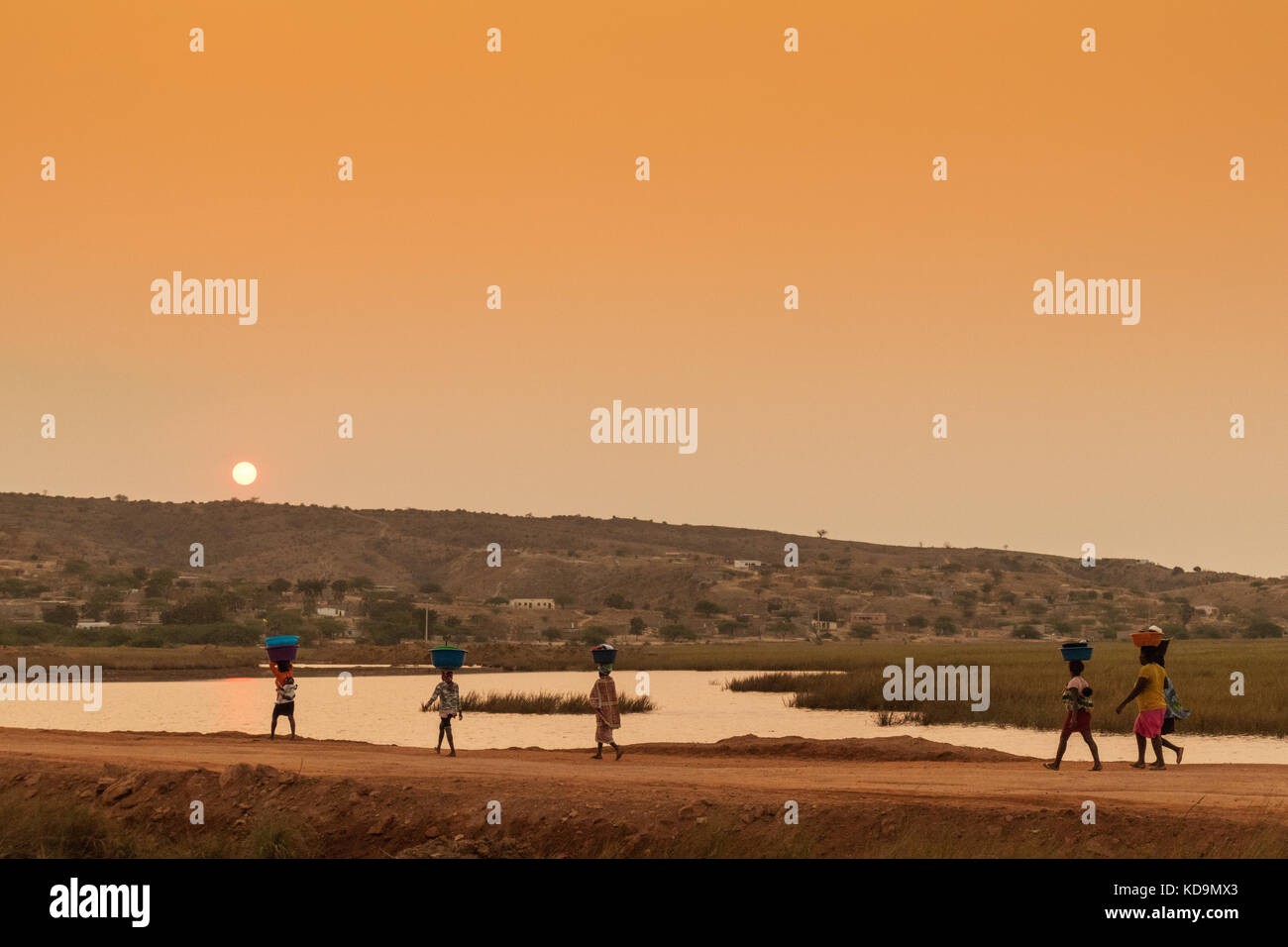 African rural people returning from work, with sunset. Sumbe. Angola ...