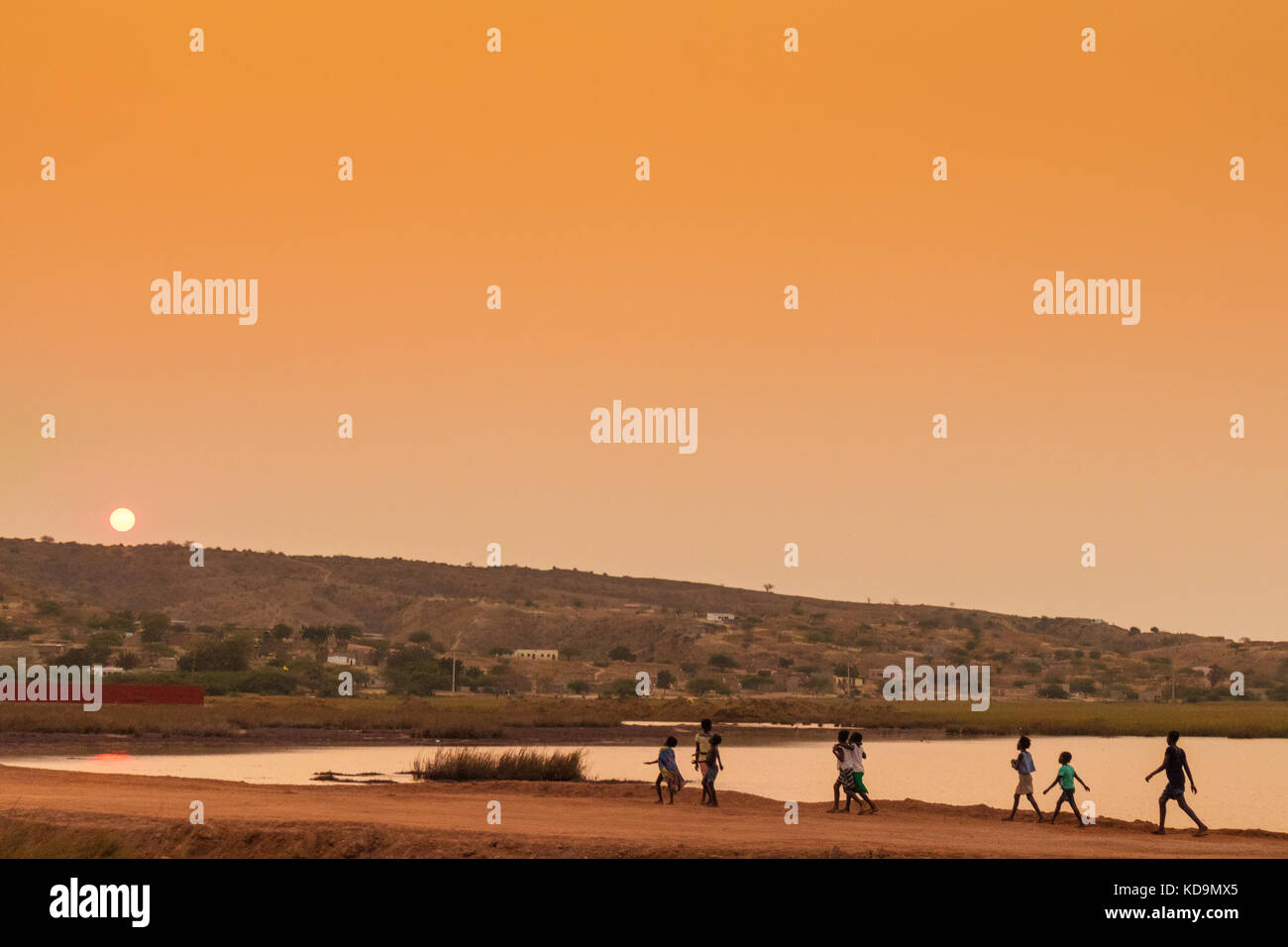 African rural people returning from work, with sunset. Sumbe. Angola ...