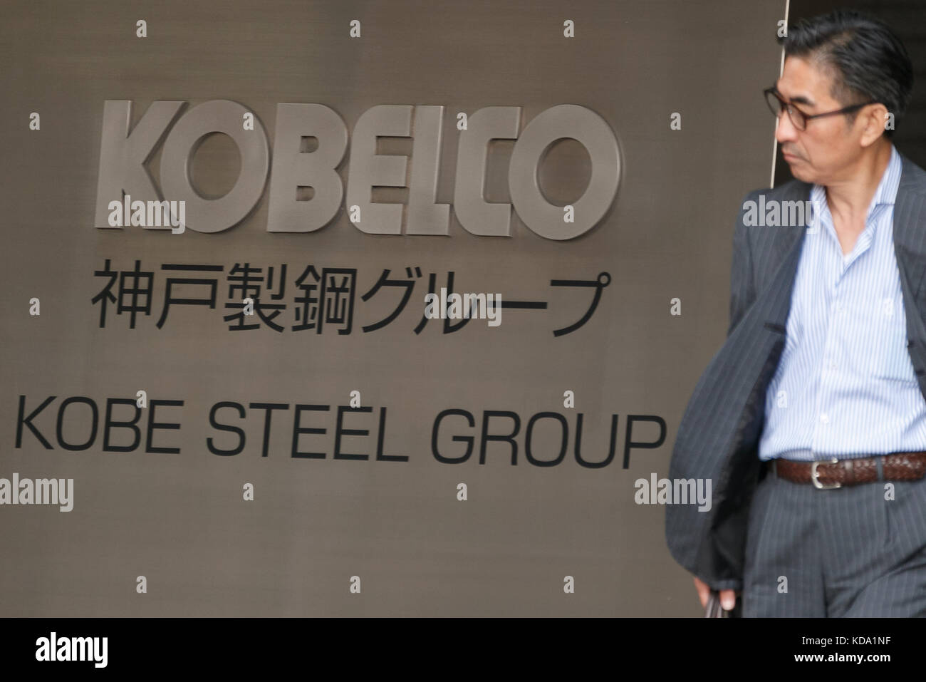 Tokyo, Japan. 12th Oct, 2017. A man walks past a signboard of Kobe ...
