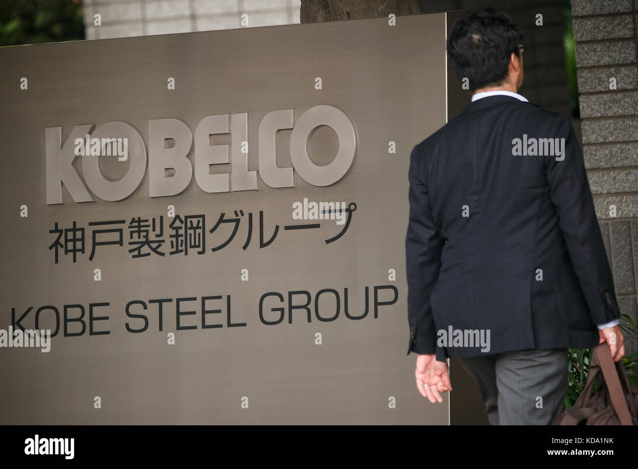 Tokyo, Japan. 12th Oct, 2017. A man walks past a signboard of Kobe ...