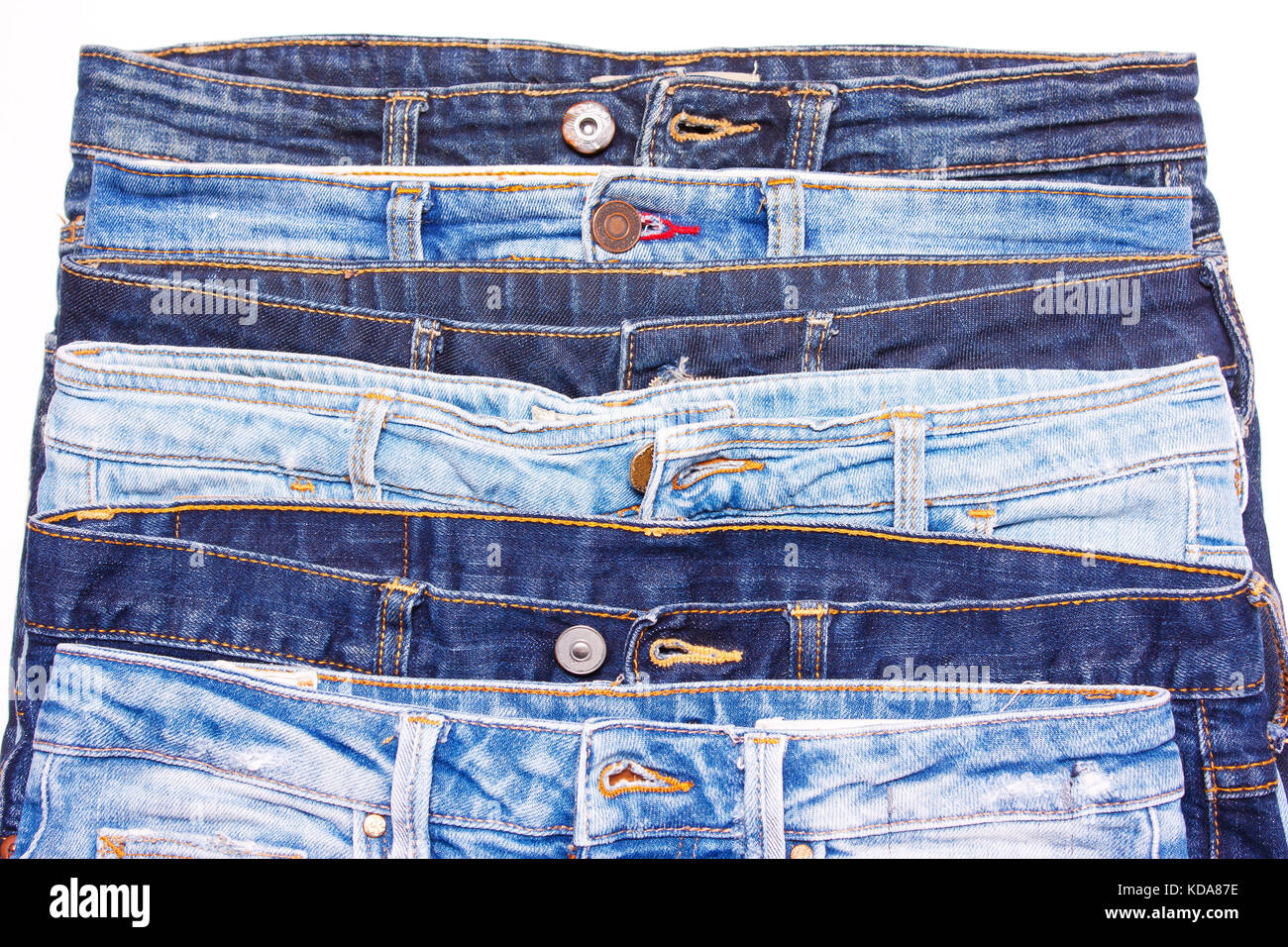 Many different blue jeans in a row on a white background Stock Photo ...