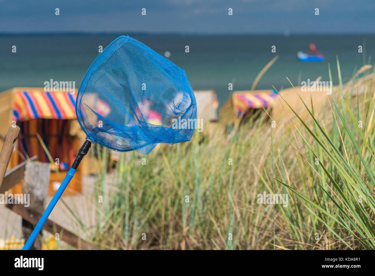 Blue hand net on the beach. Roofed wooden chairs on sandy beach in ...