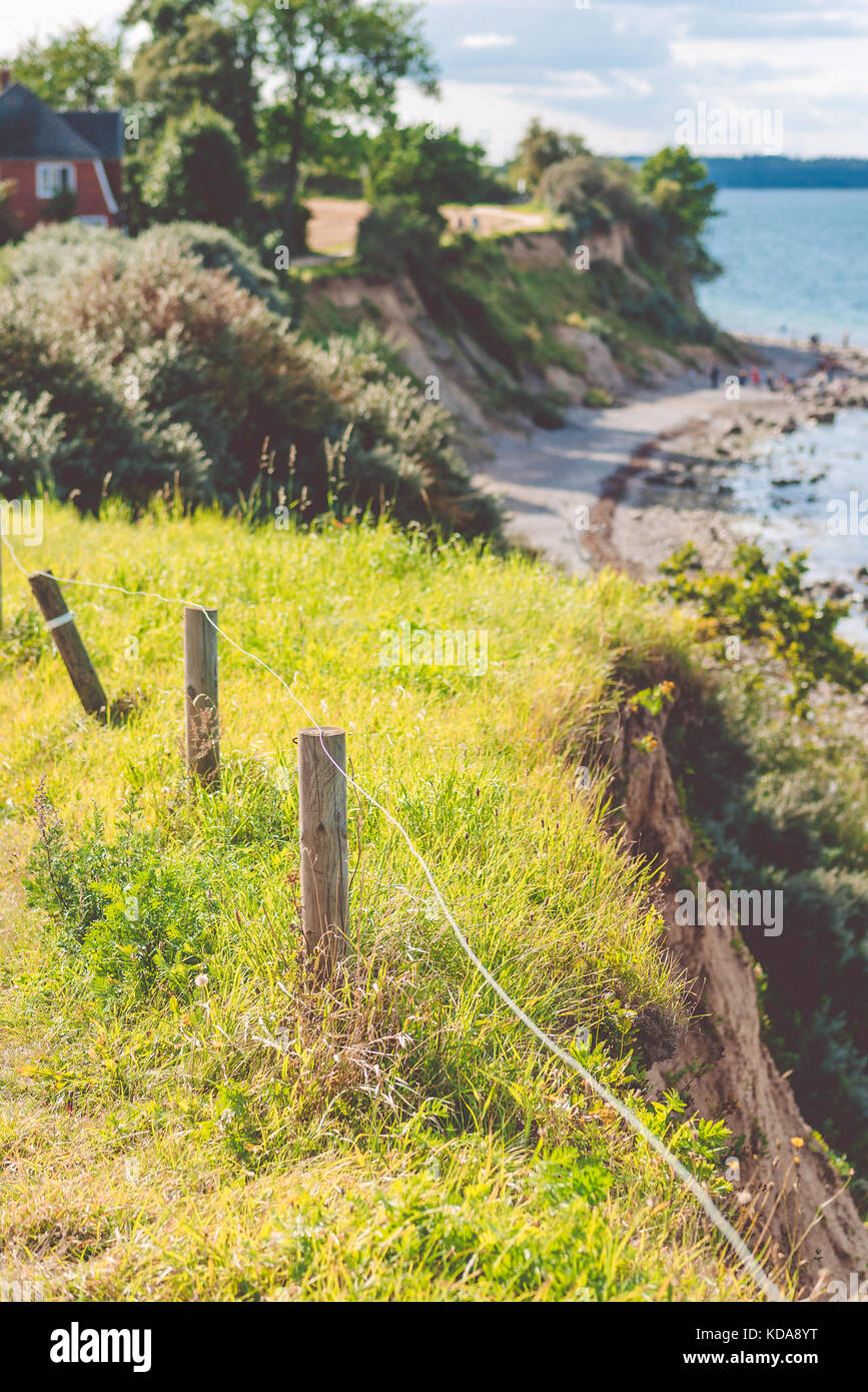 Baltic coastline. Escarpment slope lead to pebble beach. People walking ...