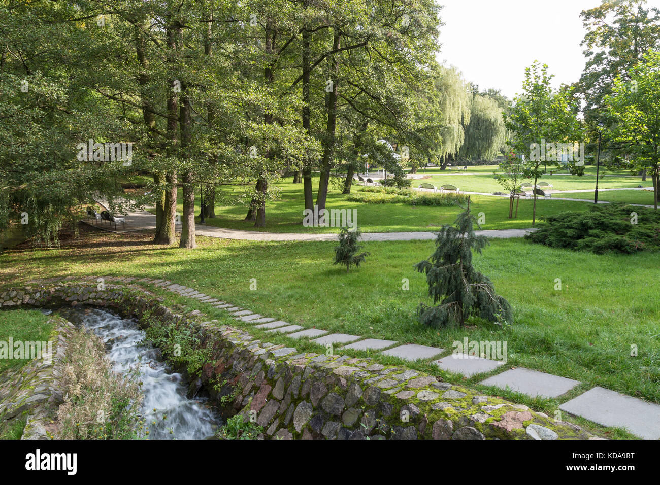View of a stream, trees and lawn at the Orunia Park. It's a public park ...