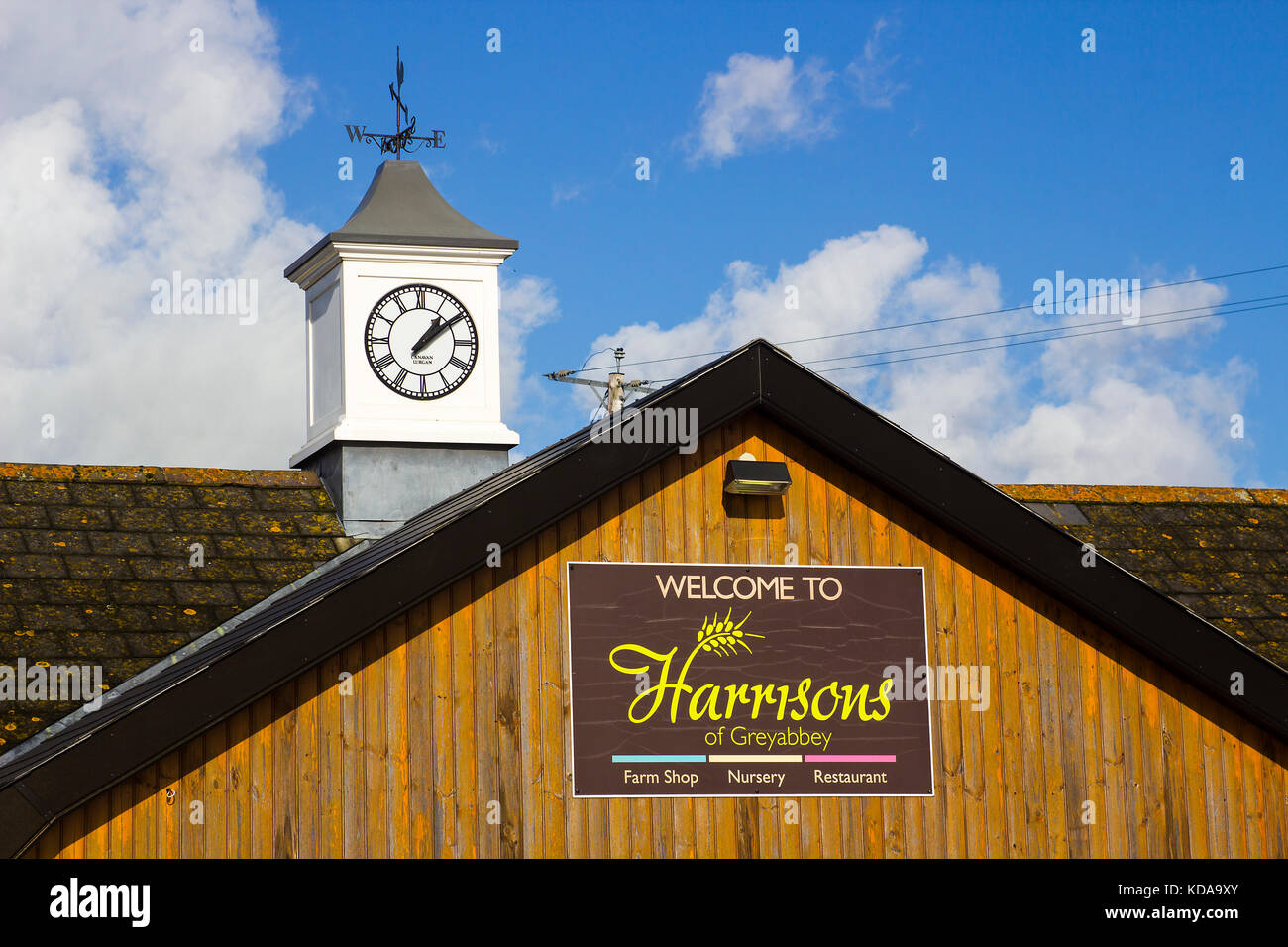 An old fashioned clock tower with a weather cock on a garden centre ...