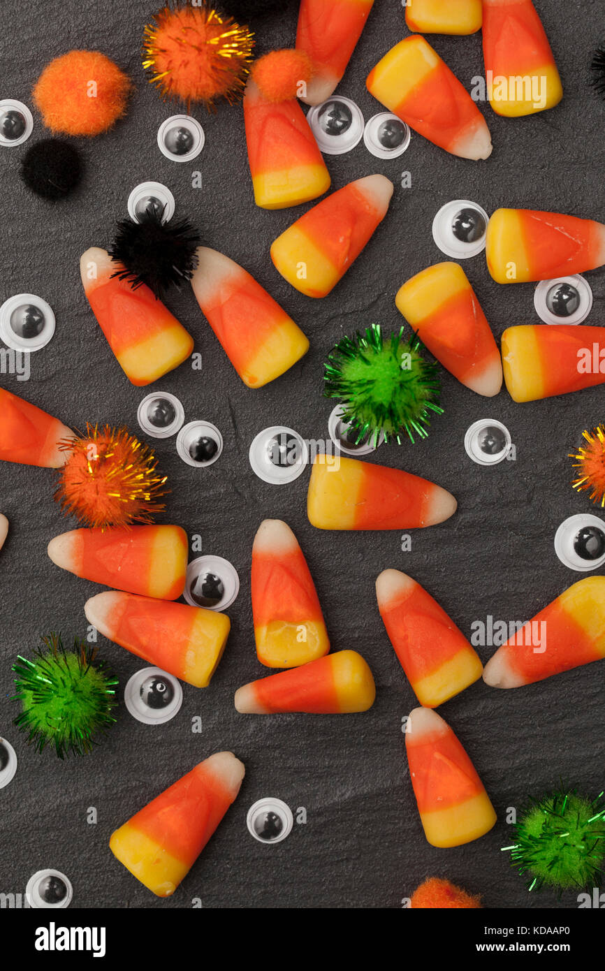Halloween candy corn sweets and googly eyes background Stock Photo - Alamy